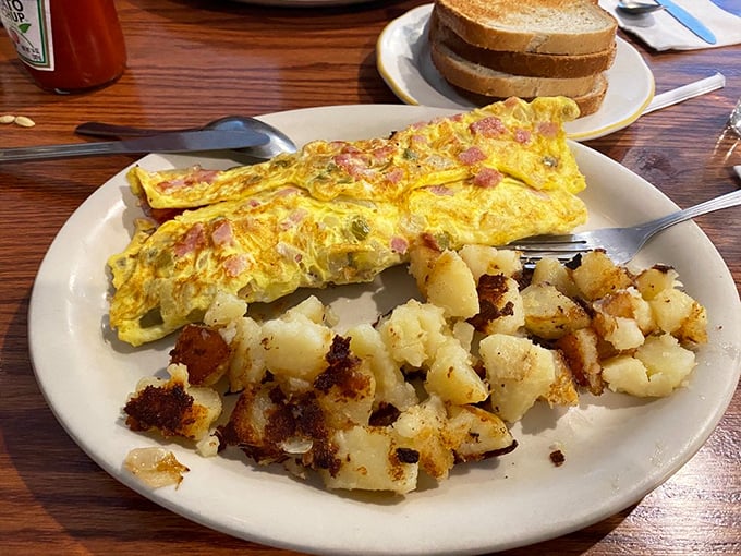 An omelet that's seen things—namely ham, peppers, and cheese—folded into fluffy eggs with the precision of an origami master.