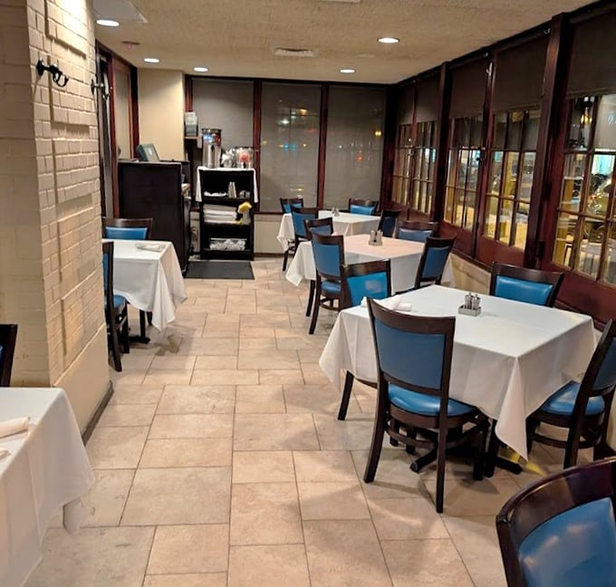 This quiet corner of the restaurant offers a more intimate dining experience, where blue chairs pop against crisp white tablecloths.