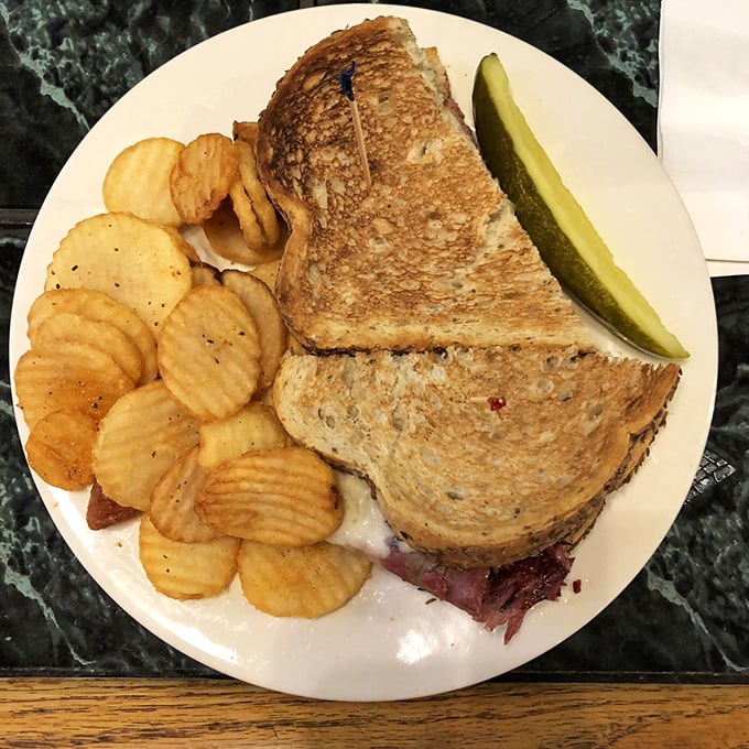 A sandwich that's achieved perfect balance – crispy grilled bread, tender meat, and just enough cheese to make you temporarily forget about your cholesterol numbers.
