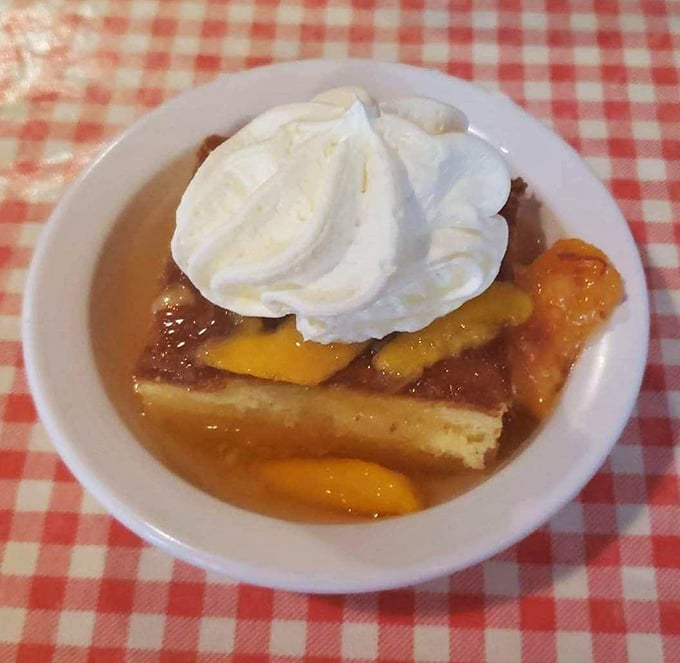 Peach cobbler swimming in its own sweet juices, topped with a cloud of whipped cream—dessert masquerading as breakfast.