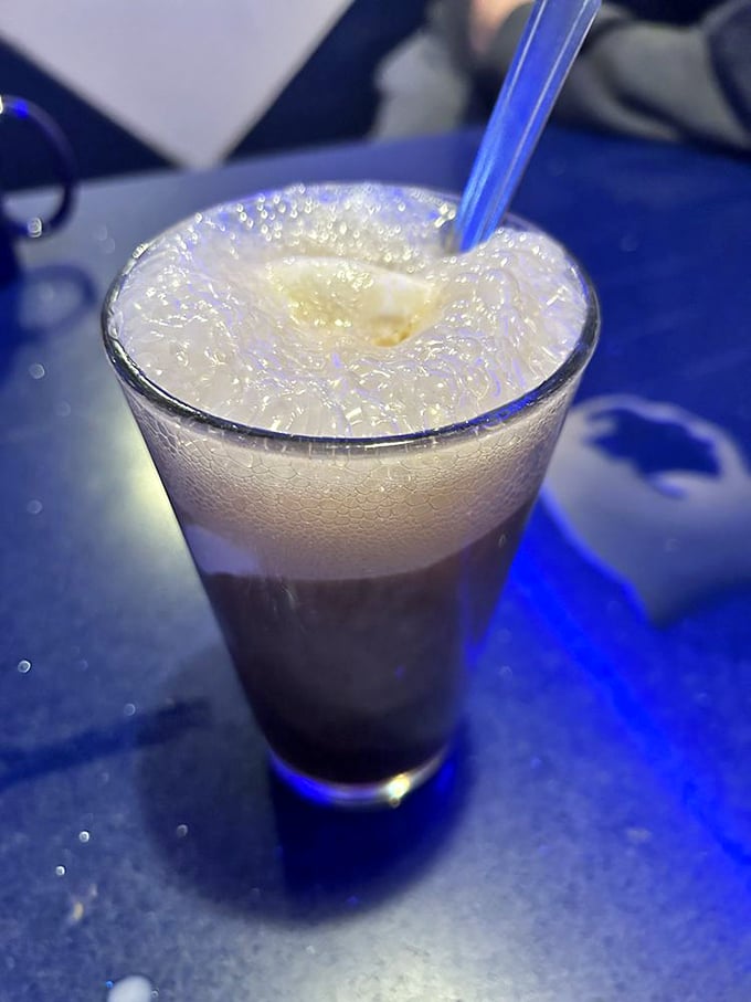 Root beer float with that perfect foam-to-liquid ratio—childhood nostalgia served in a glass, with a side of blue ambiance.