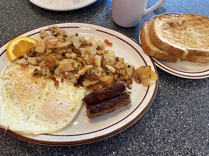 The classic American breakfast in its natural habitat – eggs, sausage, and home fries performing the morning ritual that's kept America running for generations.