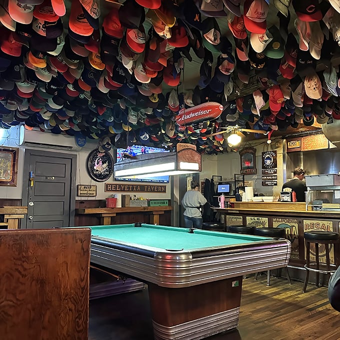 Where the magic happens—a pool table under a ceiling of caps. The ultimate test: can you sink the eight ball without getting distracted by the headwear?