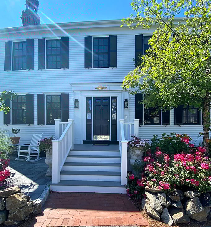 Classic Cape Cod architecture with flowers blooming everywhere—this is what charming coastal living actually looks like.