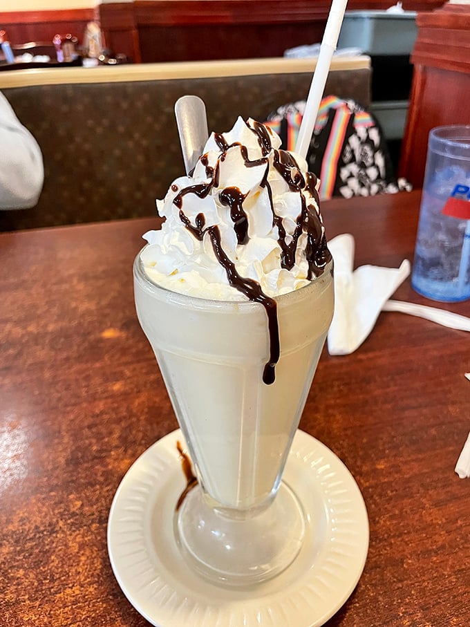 Not just a milkshake, but a towering monument to dairy devotion, where whipped cream and chocolate drizzle create a symphony in a glass.