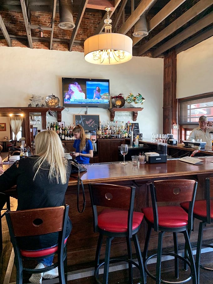 The bar's exposed brick and warm wood create that perfect sweet spot between rustic charm and polished comfort – like your favorite jeans but in restaurant form.