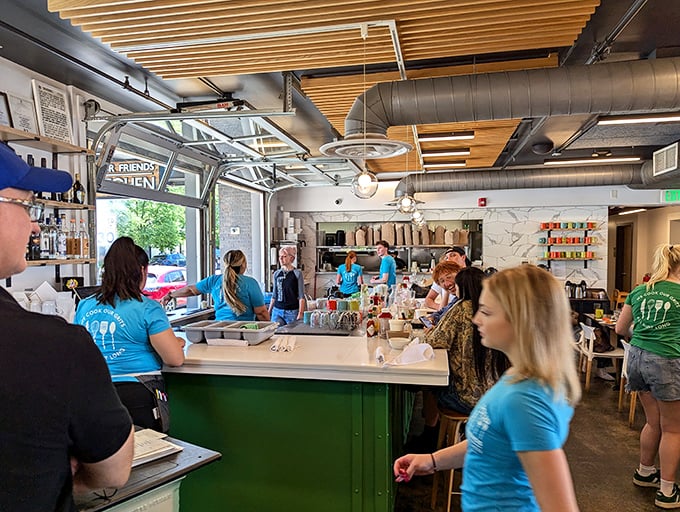 The open kitchen concept isn't just trendy—it's a stage where culinary magic happens in full view, with the green bar adding a pop of unexpected color.