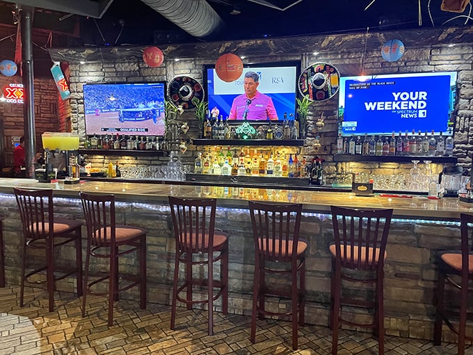 The bar's stone facade isn't just decorative—it's holding back a tequila tsunami. Those TVs ensure you won't miss the game while sipping.