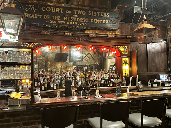 The bar at Court of Two Sisters doesn't just serve drinks—it serves history with a twist, under the warm glow of vintage lighting.
