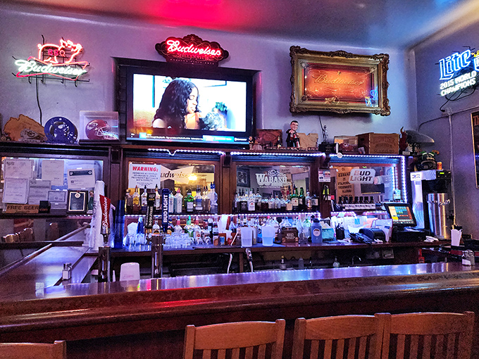 The bar area glows with neon nostalgia, offering liquid companions for your barbecue journey through the heartland's finest flavors.