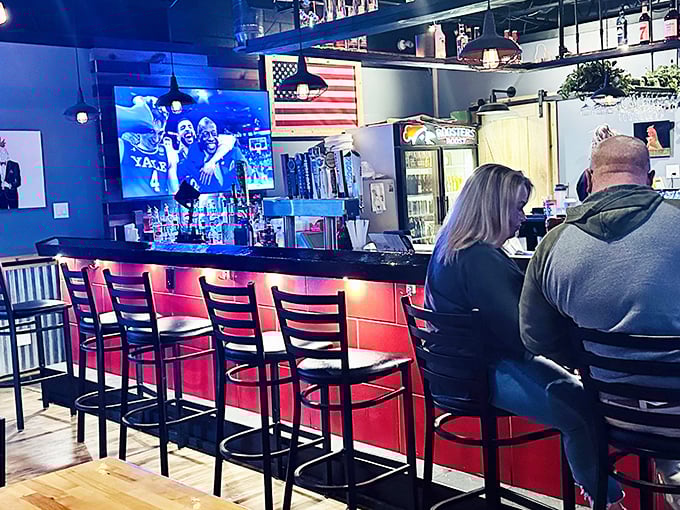 The bar area balances sports-watching with serious eating. That American flag says it all – few things are more patriotic than supporting local restaurants that do things right.