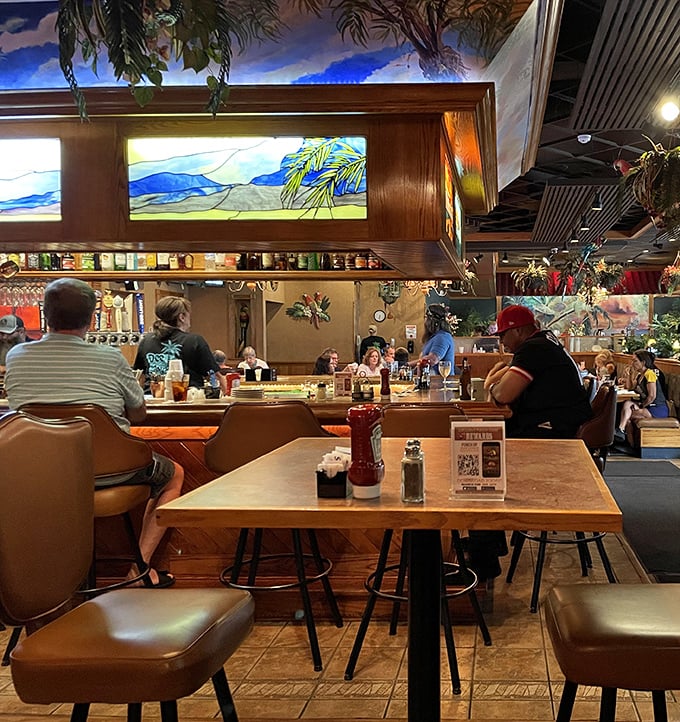 The bar area glows with stained glass warmth. Those hanging lamps cast the kind of light that makes everyone look like they're on vacation—even on a Tuesday.