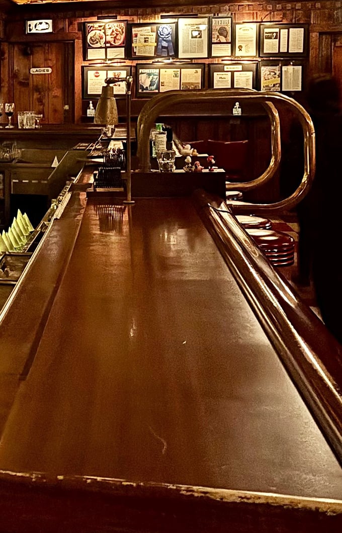 The bar counter gleams with decades of polish and promise – a front-row seat to steakhouse theater at its finest.