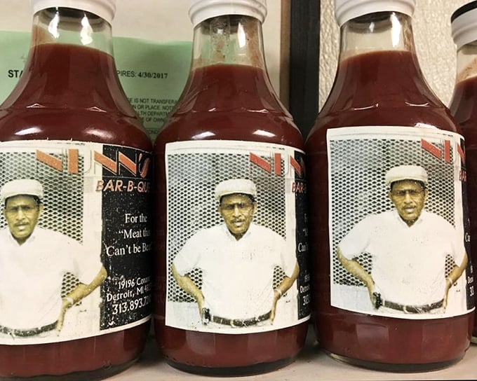 Bottles of house sauce standing like sentinels of flavor. The secret weapon that transforms good barbecue into unforgettable barbecue.