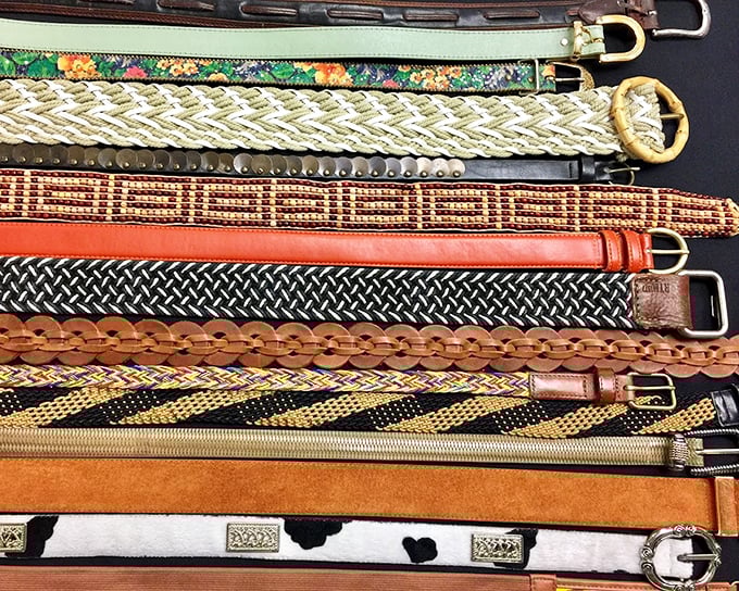 A rainbow of vintage belts that proves accessorizing has always been an art form—from cowboy-worthy leather to disco-era woven wonders.