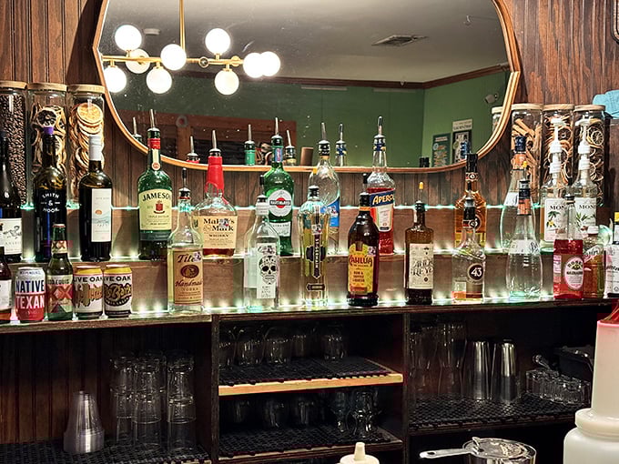 The bar display showcases Texas spirits alongside global favorites – liquid companions for your pancake journey.