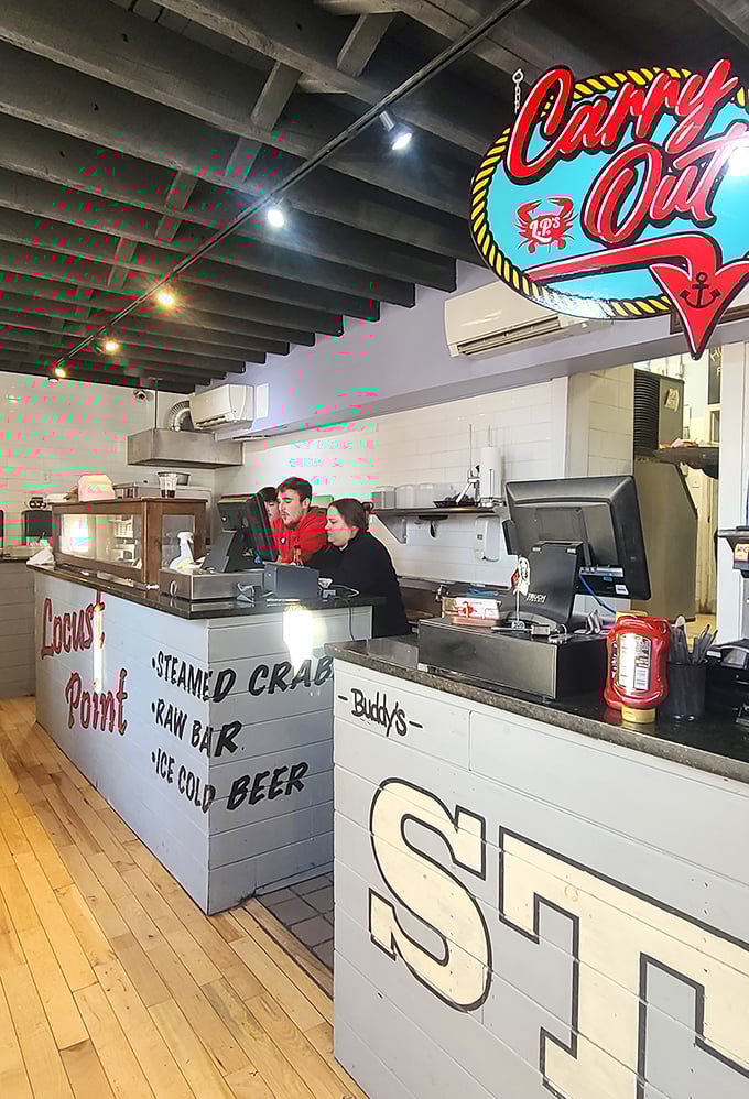 Behind the counter where seafood dreams come true, the "Carry Out" sign promises you can take the L.P. Steamers experience home—though the ambiance stays behind.