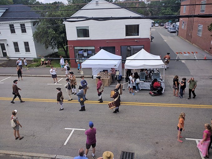 The farmers market transforms an ordinary street into a community living room where colonial drummers and modern shoppers create Exeter's unique social symphony.