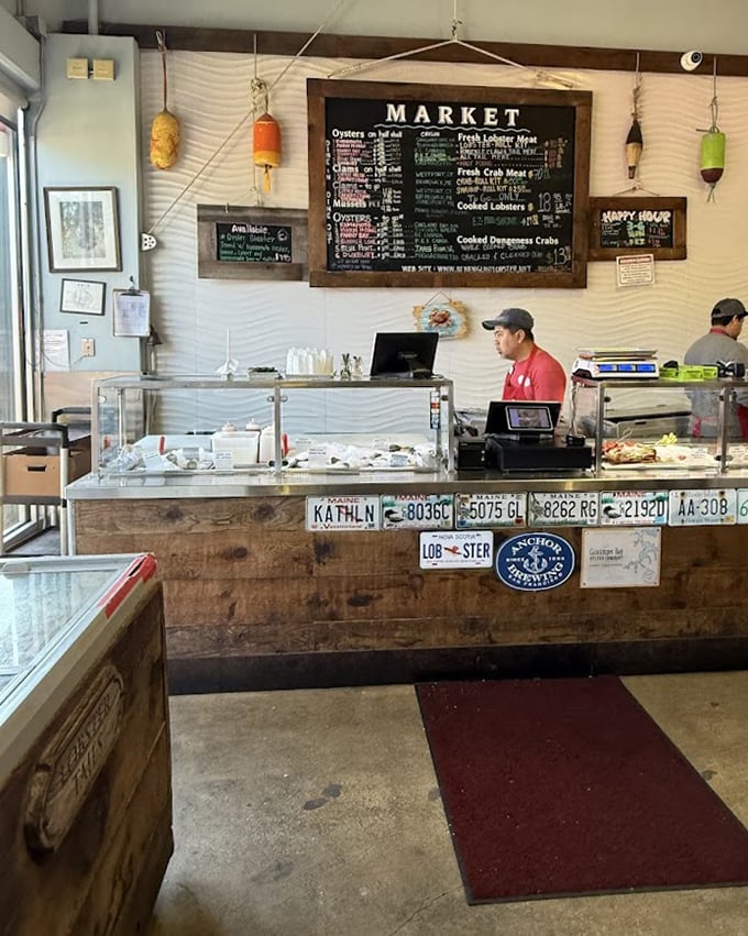 Behind the counter, where seafood dreams become reality. License plates and maritime decor remind you this is serious lobster territory.