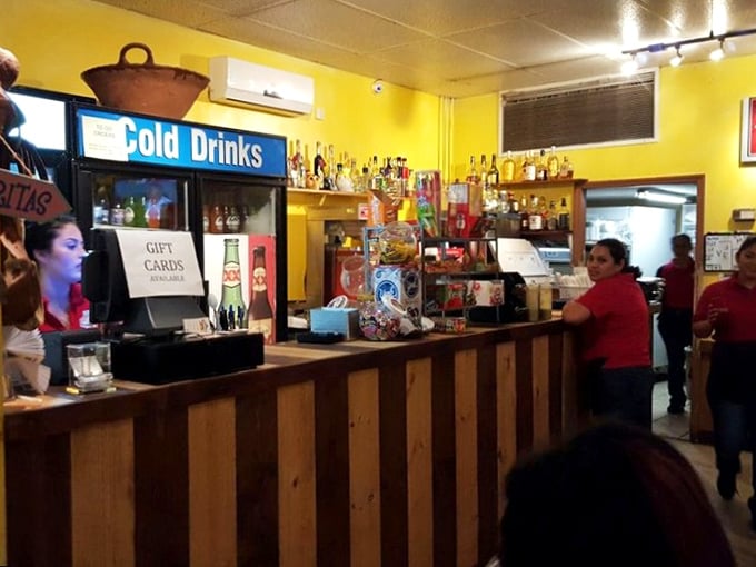 Behind the wooden counter, bottles stand at attention like soldiers guarding the secret recipes that keep locals coming back.