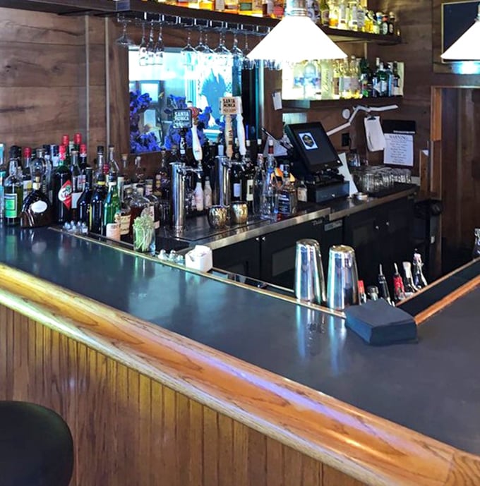 This isn't just a bar counter—it's the front row to culinary theater where classic cocktails are born and dinner plans are hatched over perfectly chilled martinis.