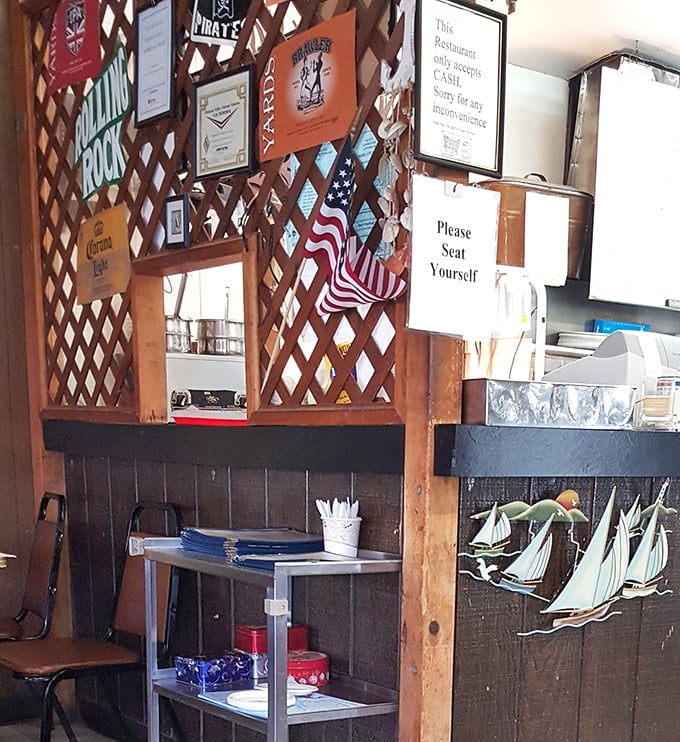 The lattice wall displays a proud collection of beer signs and maritime memorabilia—visual proof you're in a place that takes seafood seriously, not itself.