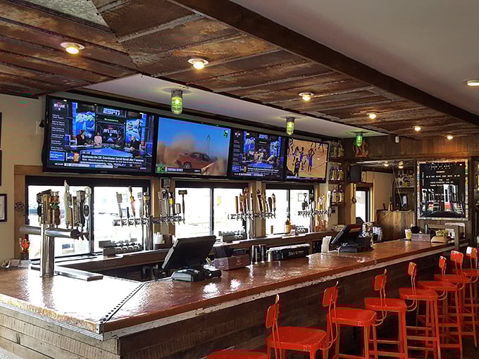 The bar's copper top gleams under the lights, while those bright red stools practically whisper, "Sit here and stay awhile."
