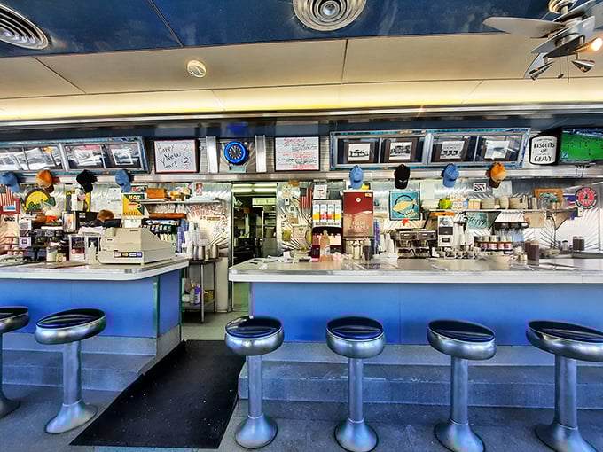 The counter view—where breakfast theater unfolds and regulars claim their spots like senators on the floor of Congress.
