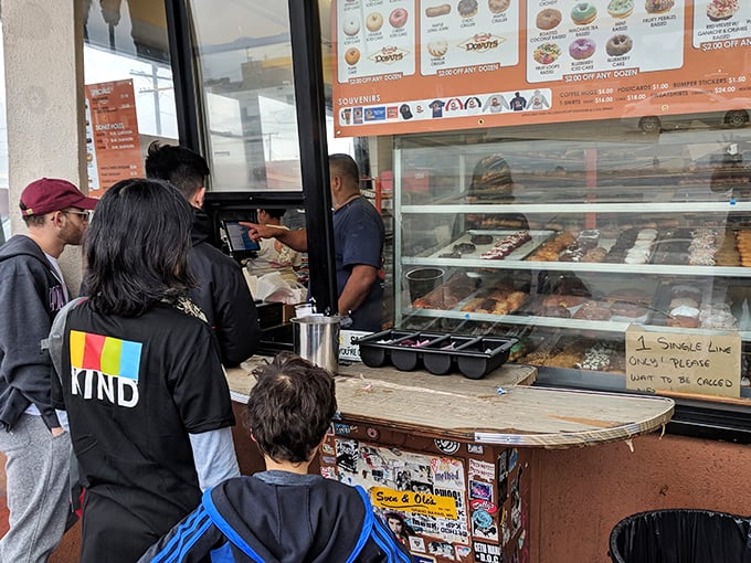 The line forms early and moves quickly—a diverse cross-section of LA united by the universal language of fried dough.