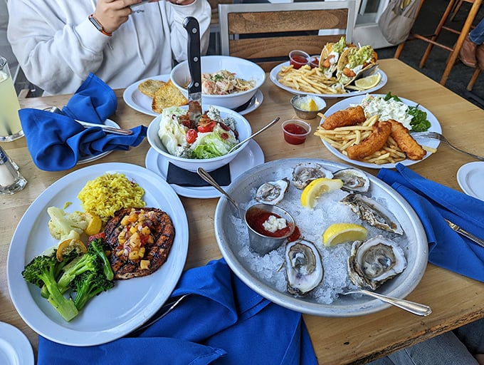 A feast fit for Neptune himself – fresh oysters, blackened fish, and crispy fries creating the kind of spread that makes everyone at neighboring tables envious.