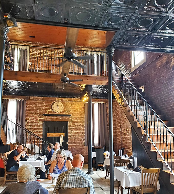 Soaring ceilings and exposed brick create a dining cathedral where conversations flow as freely as the wine—a two-story experience for all five senses.