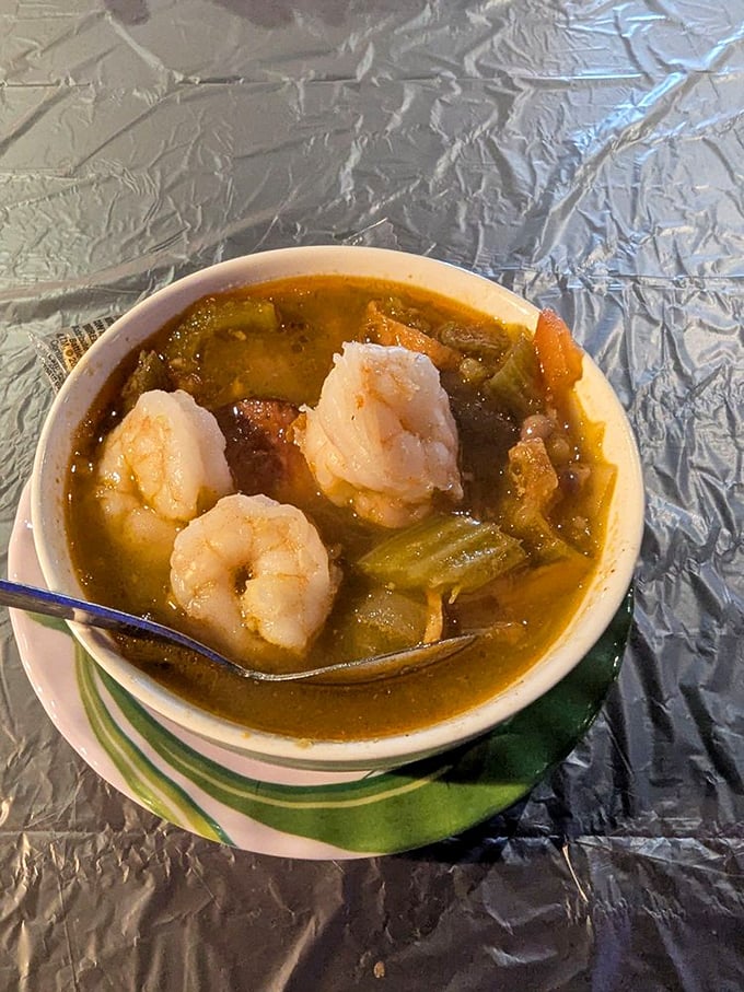 This isn't just gumbo—it's a bowl of Louisiana heritage with plump shrimp floating like treasures in a rich, roux-darkened sea.