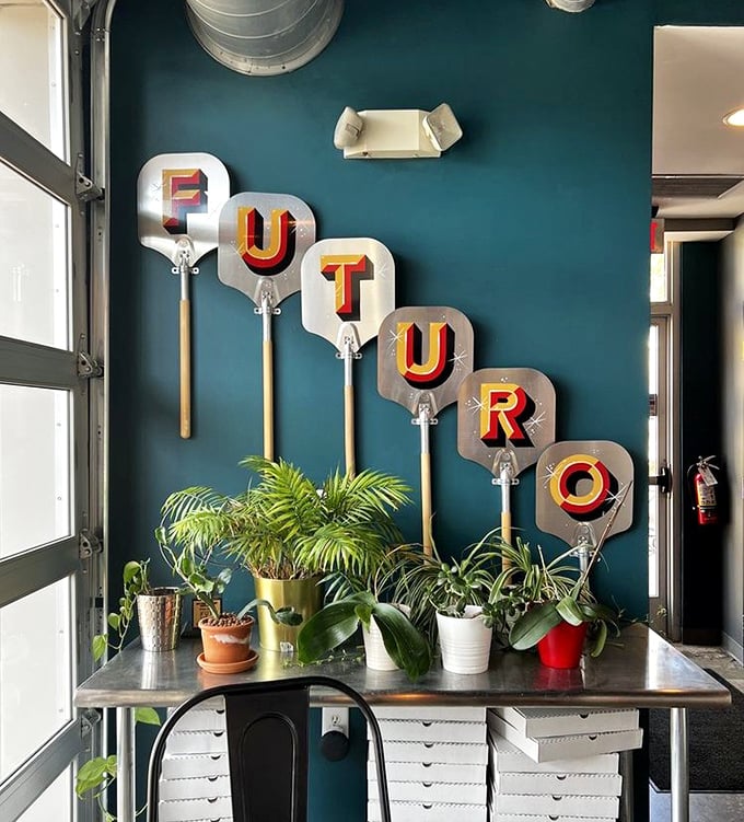 Pizza peels mounted on a teal wall spell out "FUTURO" – a stylish reminder that you're in the hands of people who take their craft seriously.