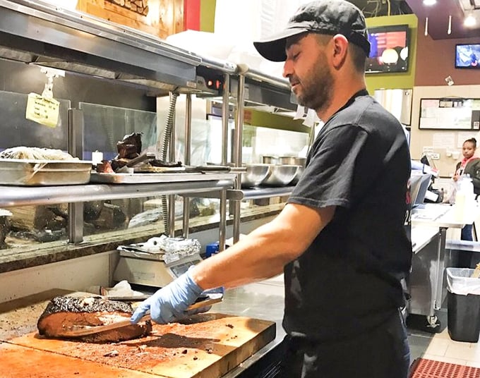 The kitchen pass—where barbecue dreams materialize. That cornbread waiting patiently is about to make someone's day exponentially better.