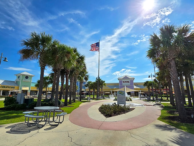 Palm trees and American flags create a distinctly Southern welcome at the outlet's central plaza, where shopping becomes a patriotic duty.
