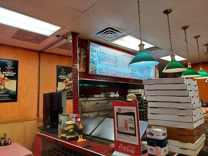 Behind every great pizza is a counter like this—organized chaos where magic happens under green lamps and beside stacked boxes awaiting their precious cargo.