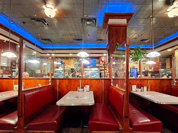 Red vinyl booths that have cradled thousands of conversations—from first dates to philosophical debates—all under the watchful glow of that distinctive blue ceiling.