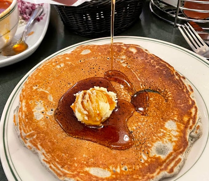 Pancake perfection in its natural habitat—golden, fluffy, and swimming in syrup like it's training for the breakfast Olympics.