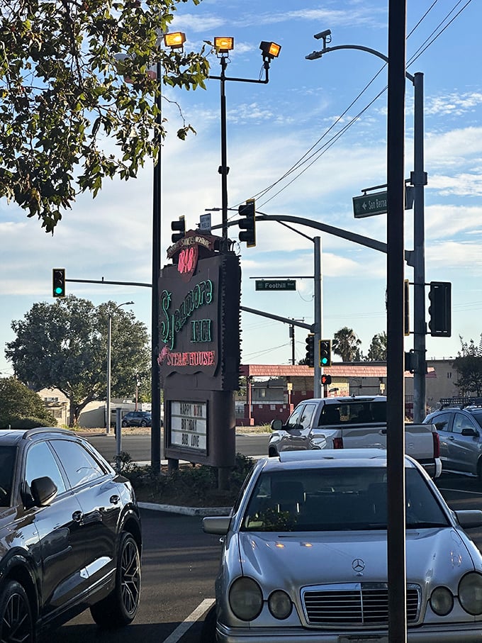 The vintage neon sign glows against the California sky, a beacon for hungry travelers since before GPS told us where to eat.