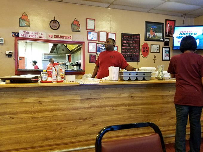 Behind the counter, where the magic happens. That sign isn't kidding – this is definitely NOT fast food, and that's precisely the point.