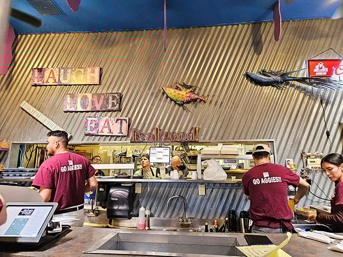 Behind the counter where culinary magic happens, with the "LAUGH LOVE EAT" mantra serving as both decoration and mission statement.
