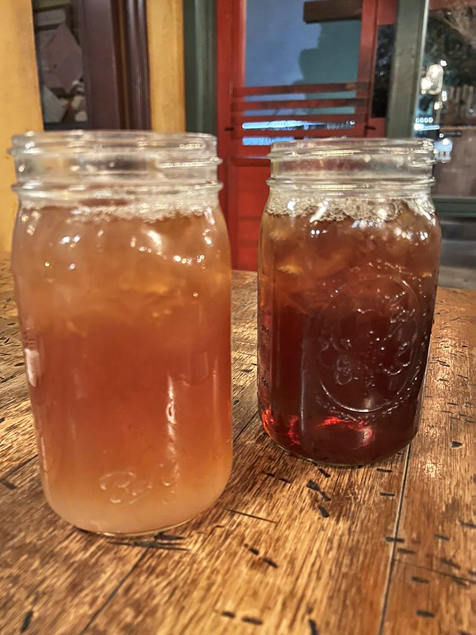 Sweet tea and something darker – the official beverages of serious BBQ appreciation, served in jars because glasses are too fancy.