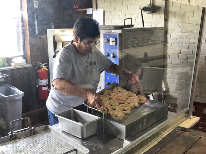 Watching a master baker at work is like seeing a conductor lead an orchestra – except instead of music, you get perfectly golden pretzels as the finale.