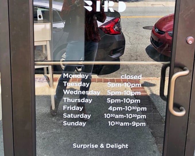 The door promises "Surprise & Delight" beneath the hours—perhaps the most honest advertising you'll ever see on a restaurant entrance.