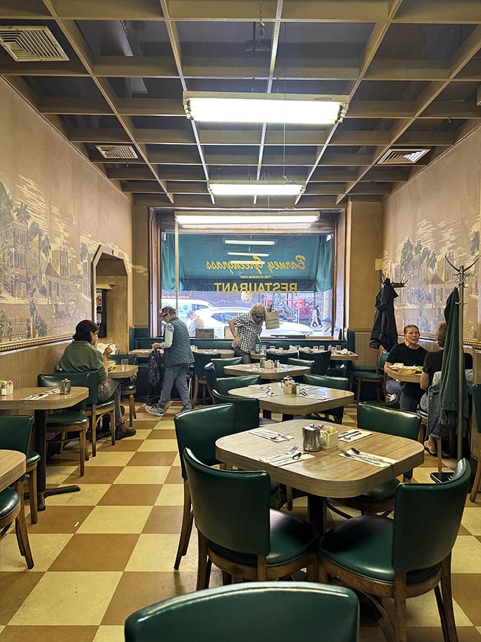 Green chairs against checkerboard floors create the stage where culinary memories are made—no fancy design needed when the food is this good.
