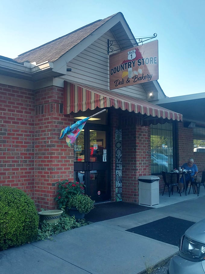 The Country Store sign swings with promise. Inside awaits sandwich magic that makes the journey worthwhile.