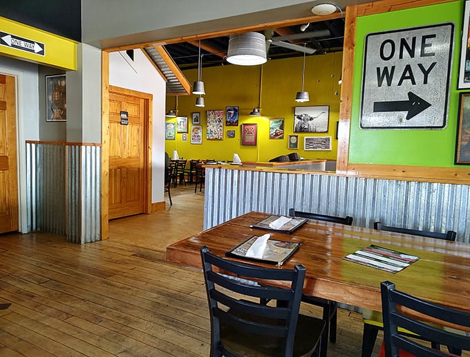 Wooden tables bathed in natural light, corrugated metal accents, and that "One Way" sign pointing toward more BBQ—they know what you're really here for.