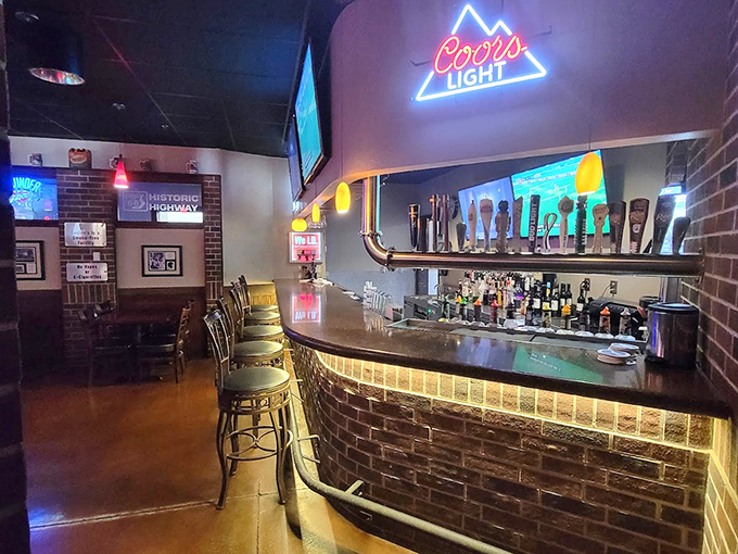 The bar area glows with neon signs and offers a front-row seat to watch skilled bartenders craft drinks that complement the roadhouse menu perfectly.