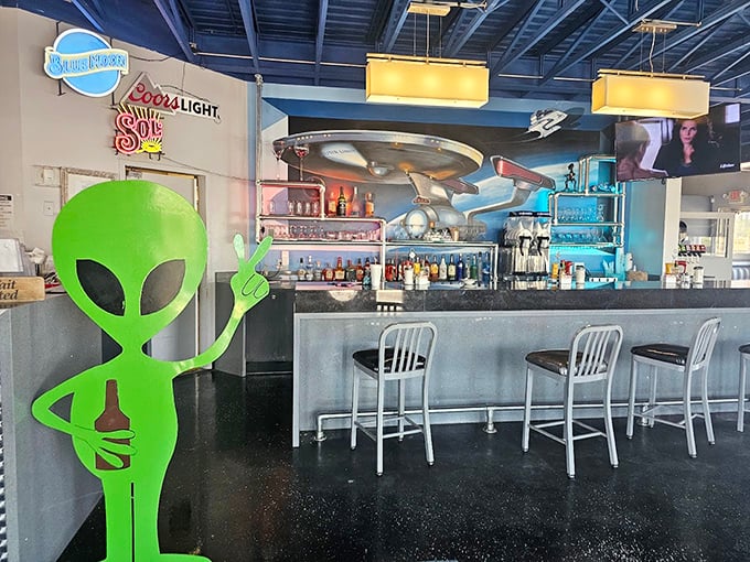 The bar area, complete with alien greeter, serves up cosmic cocktails under a UFO light fixture. Even extraterrestrials need a good happy hour.