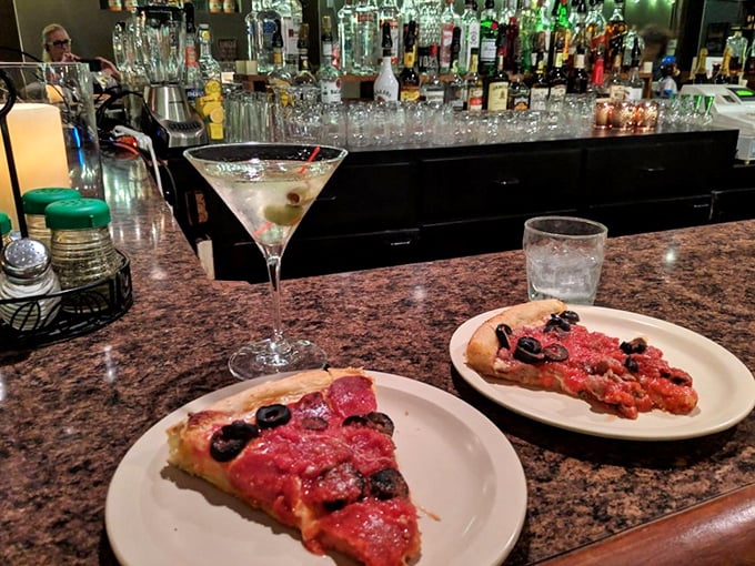 Martinis and pizza slices at the bar – a pairing that feels both rebellious and absolutely right. The perfect first-date litmus test.